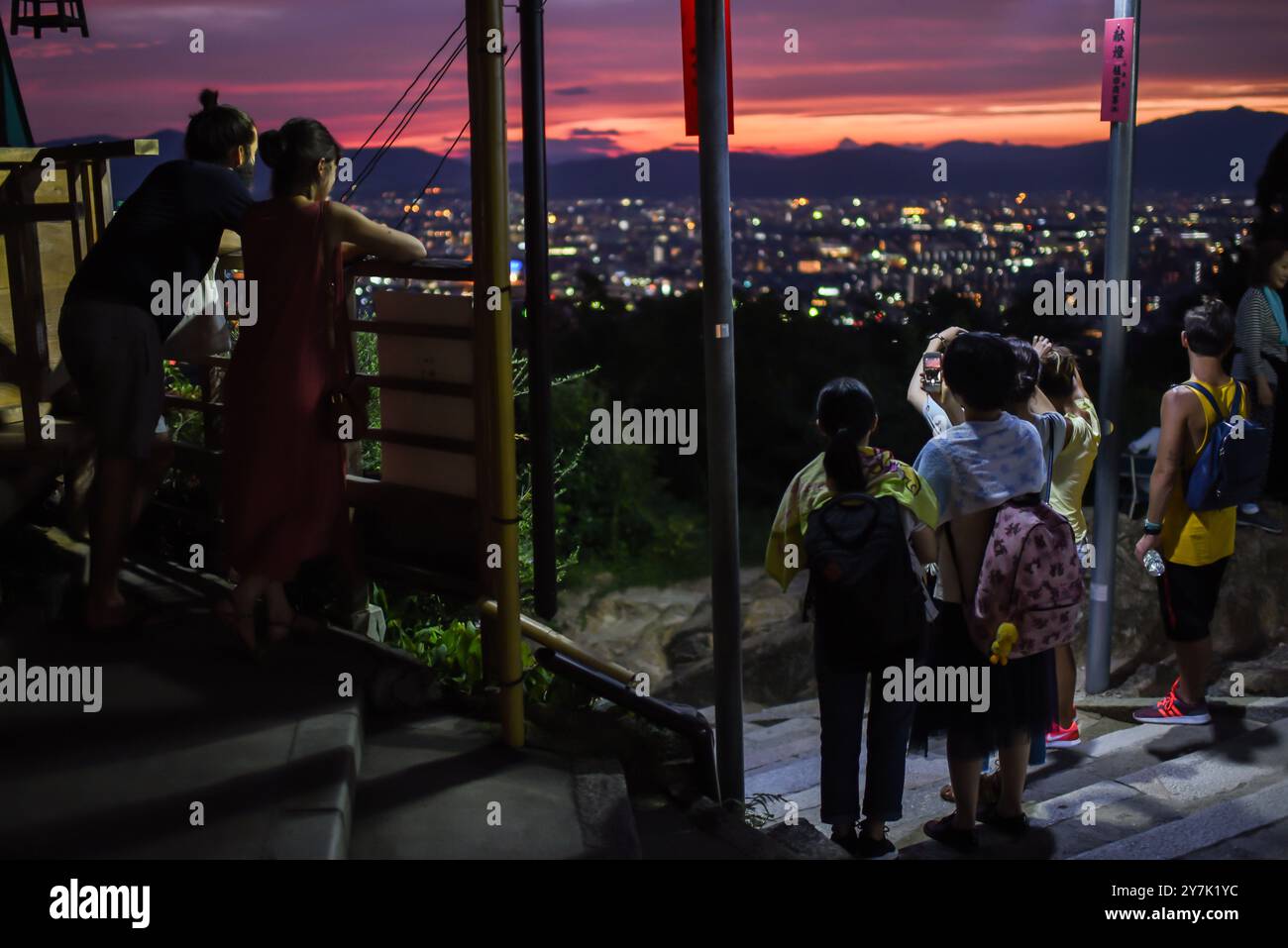 People enjoy the night views of Kyoto from viewpoint at Fushimi Inari Taisha temple, Kyoto ...
