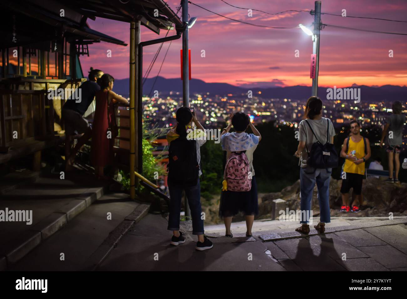 People enjoy the night views of Kyoto from viewpoint at Fushimi Inari Taisha temple, Kyoto ...