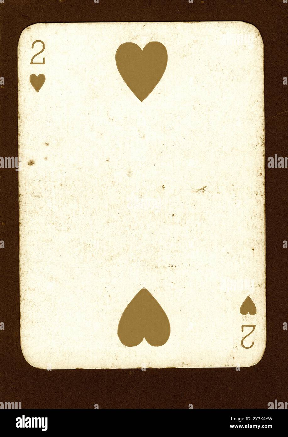 A vintage two of hearts playing card in sepia on a black background ...
