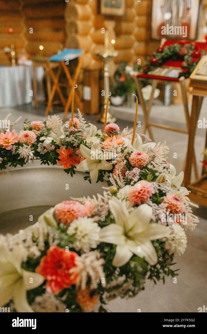 A vibrant bouquet of lilies and dahlias adorns the altar of a wooden ...