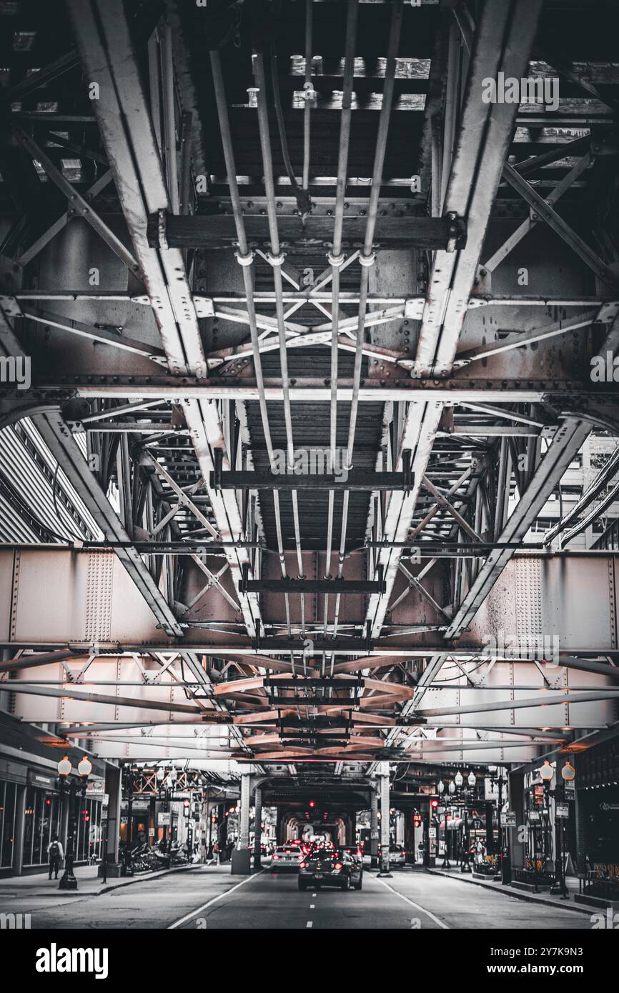 Underside view of elevated train track with city traffic below ...