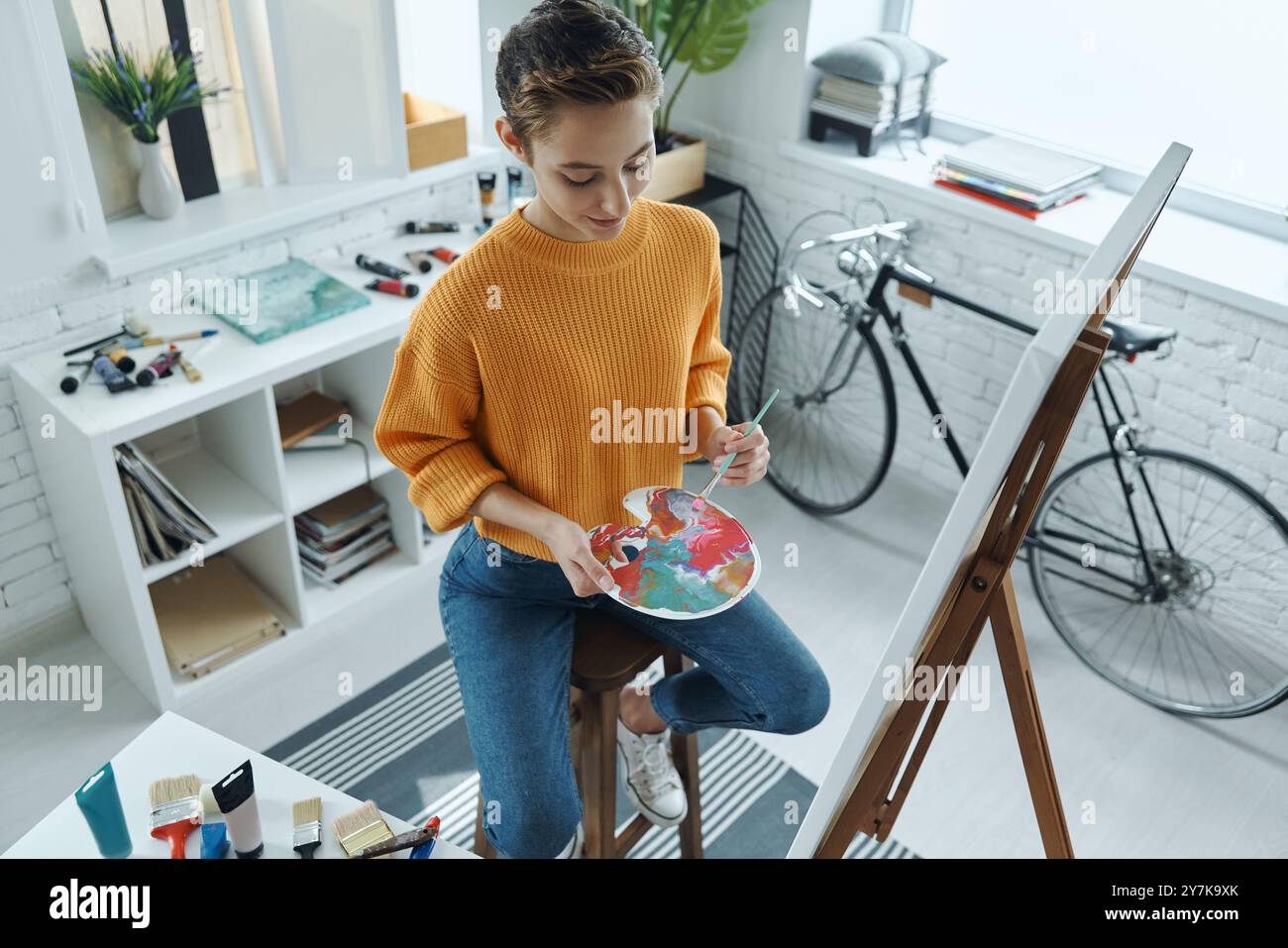 Top view of beautiful young woman mixing colors while drawing in art ...