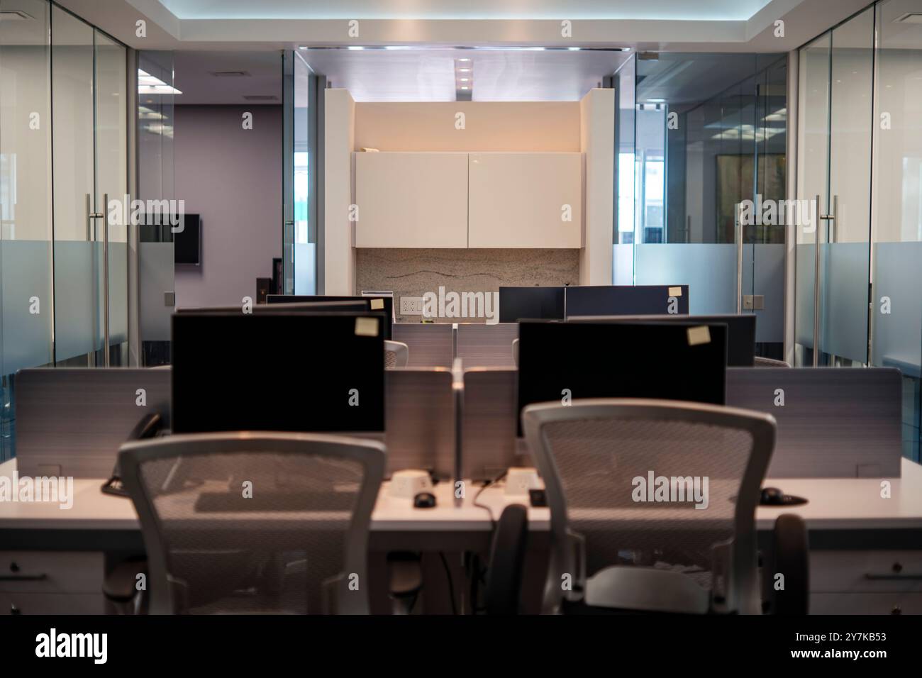 Modern office with computer desks and glass partitions, showcasing a ...