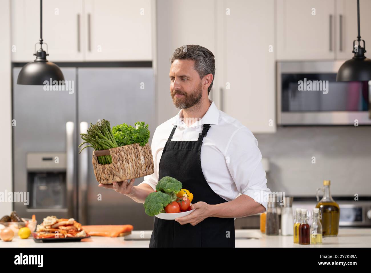 Hispanic man cooking home healthy food in apron choose ingredient for ...
