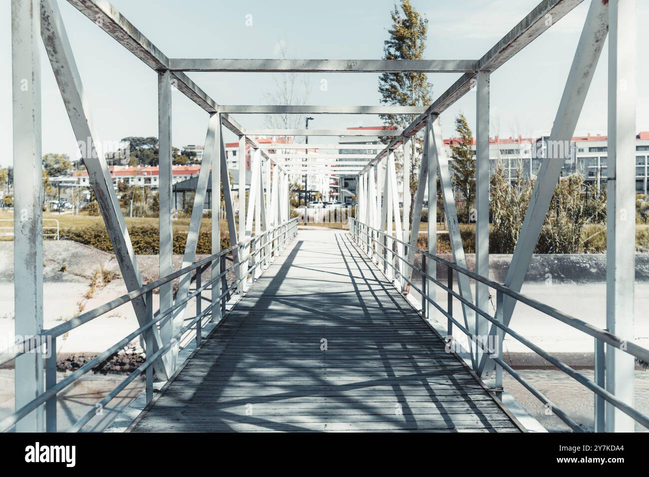 A wide-angle shot of a metal pedestrian bridge with a geometric ...