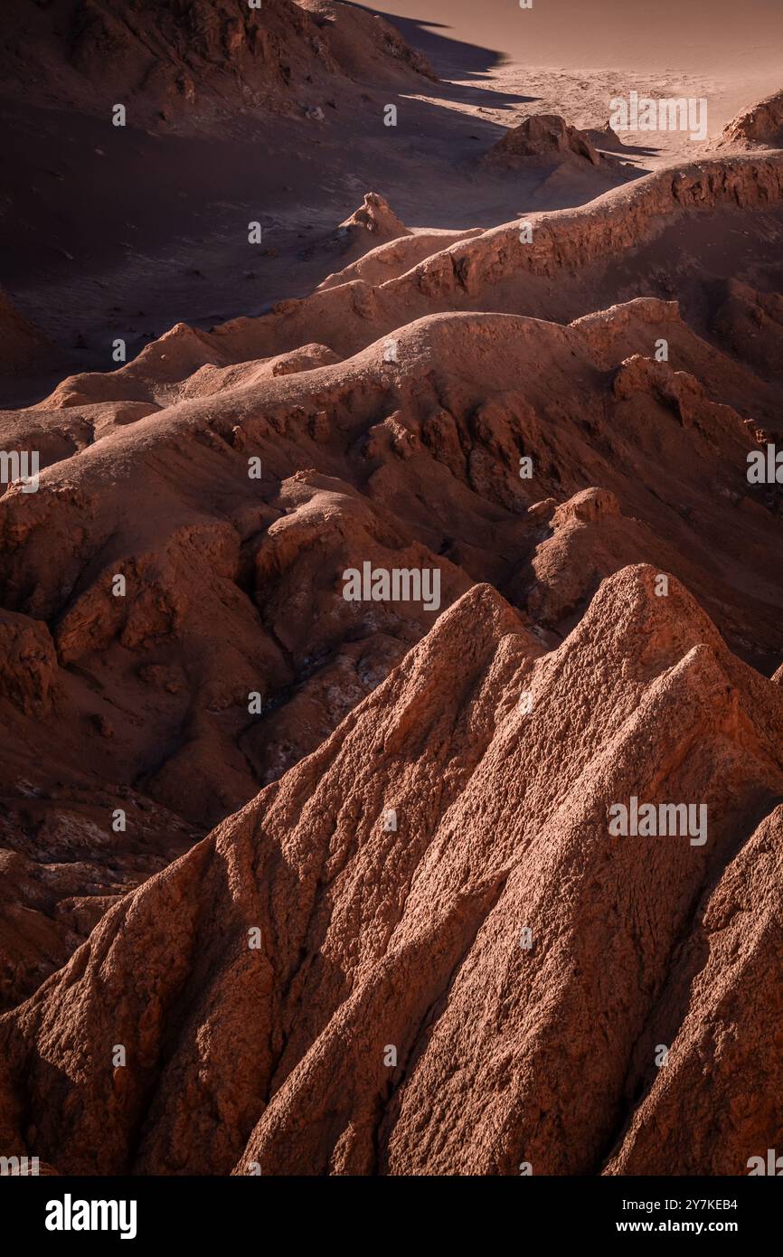 Aerial view of rugged desert terrain with sharp ridges and deep shadows ...