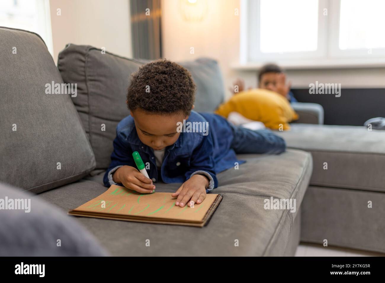 Cute boy using felt-tip pen creates vibrant drawings in his album ...