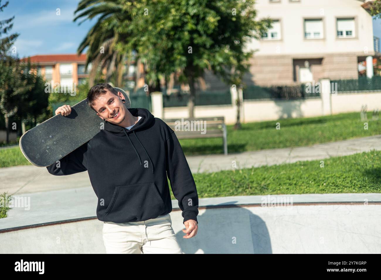 copyspace smiling skater confidently posing for the camera, holding ...