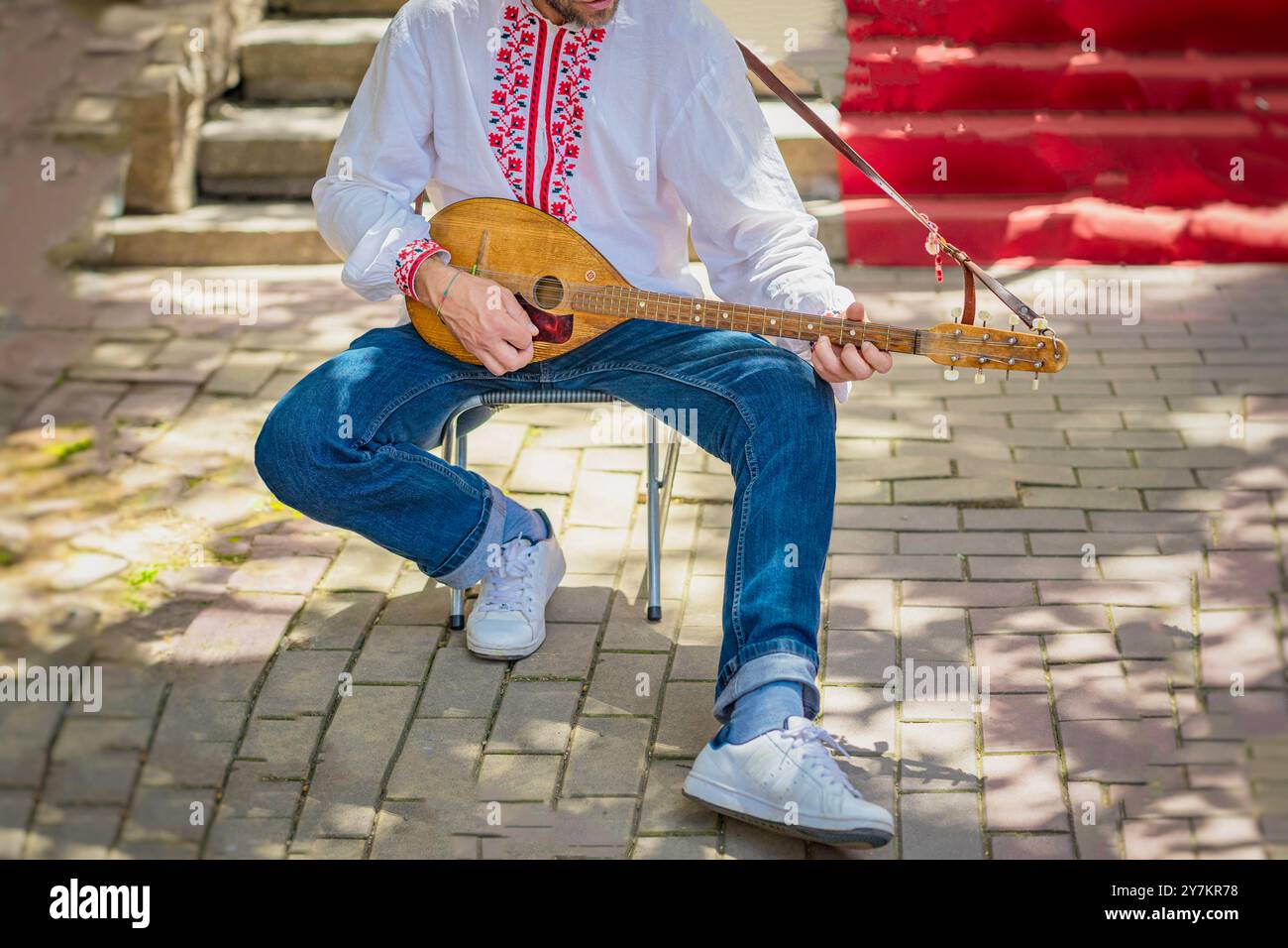 Abstract Man playing traditional folk string instrument while wearing a ...
