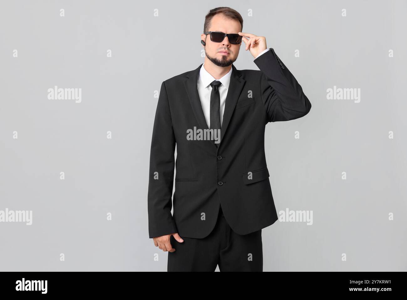 Young bodyguard in suit and sunglasses on grey background Stock Photo ...