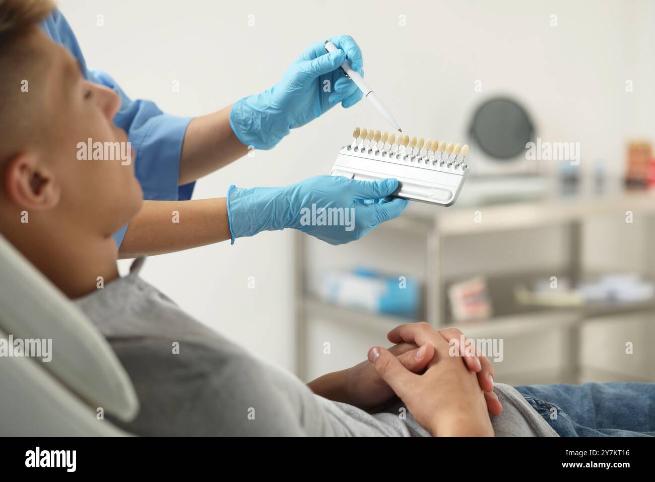 Doctor and patient choosing shade on teeth color palette in clinic ...