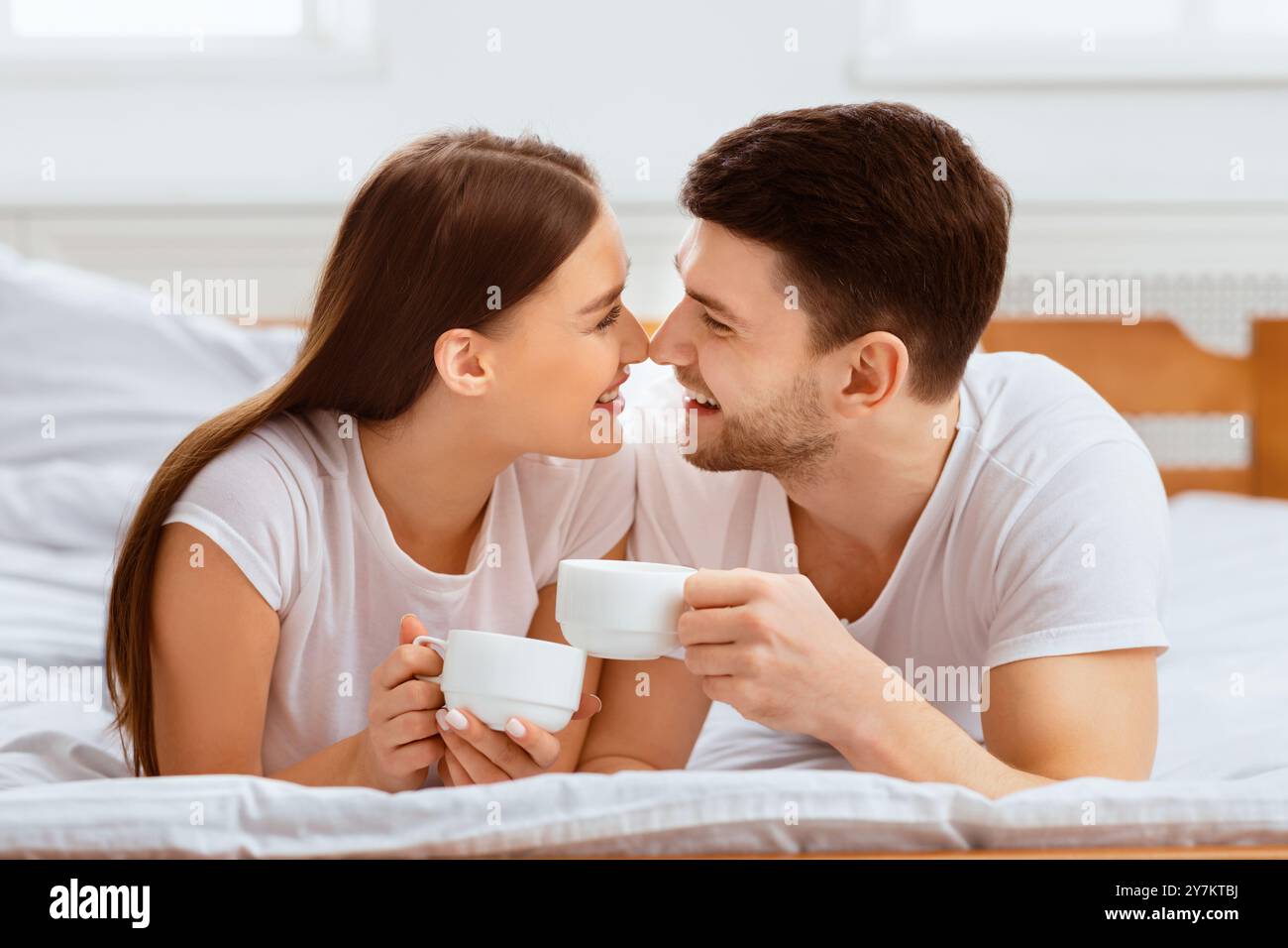 Couple Having Morning Coffee Lying In Bed At Home Stock Photo - Alamy