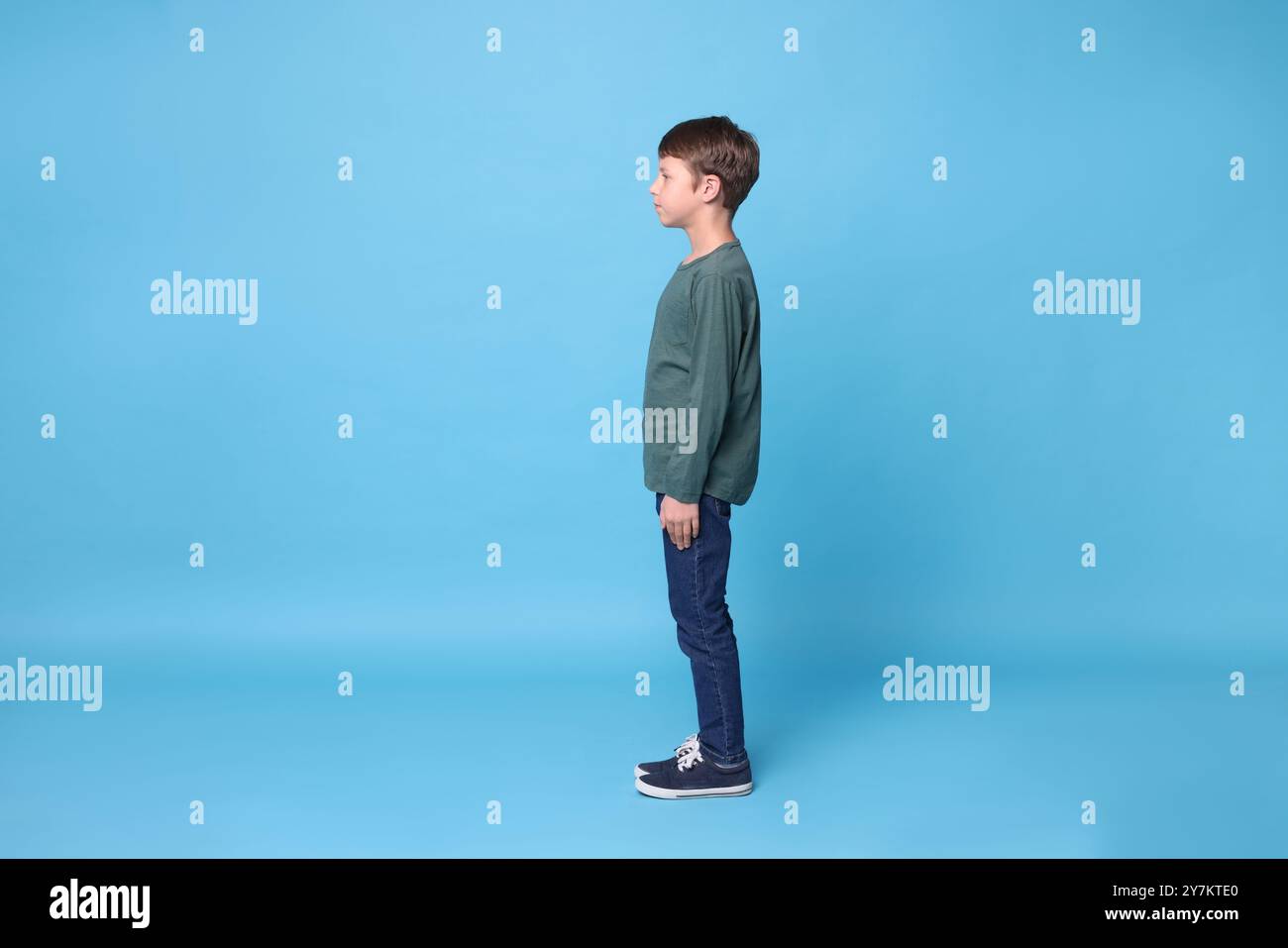 Boy with correct posture on light blue background Stock Photo - Alamy
