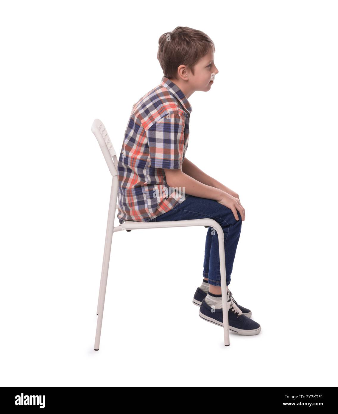 Boy with incorrect posture sitting on chair against white background ...