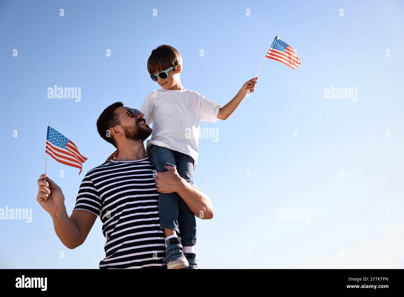 Happy father and son with flags of USA outdoors. Space for text Stock ...