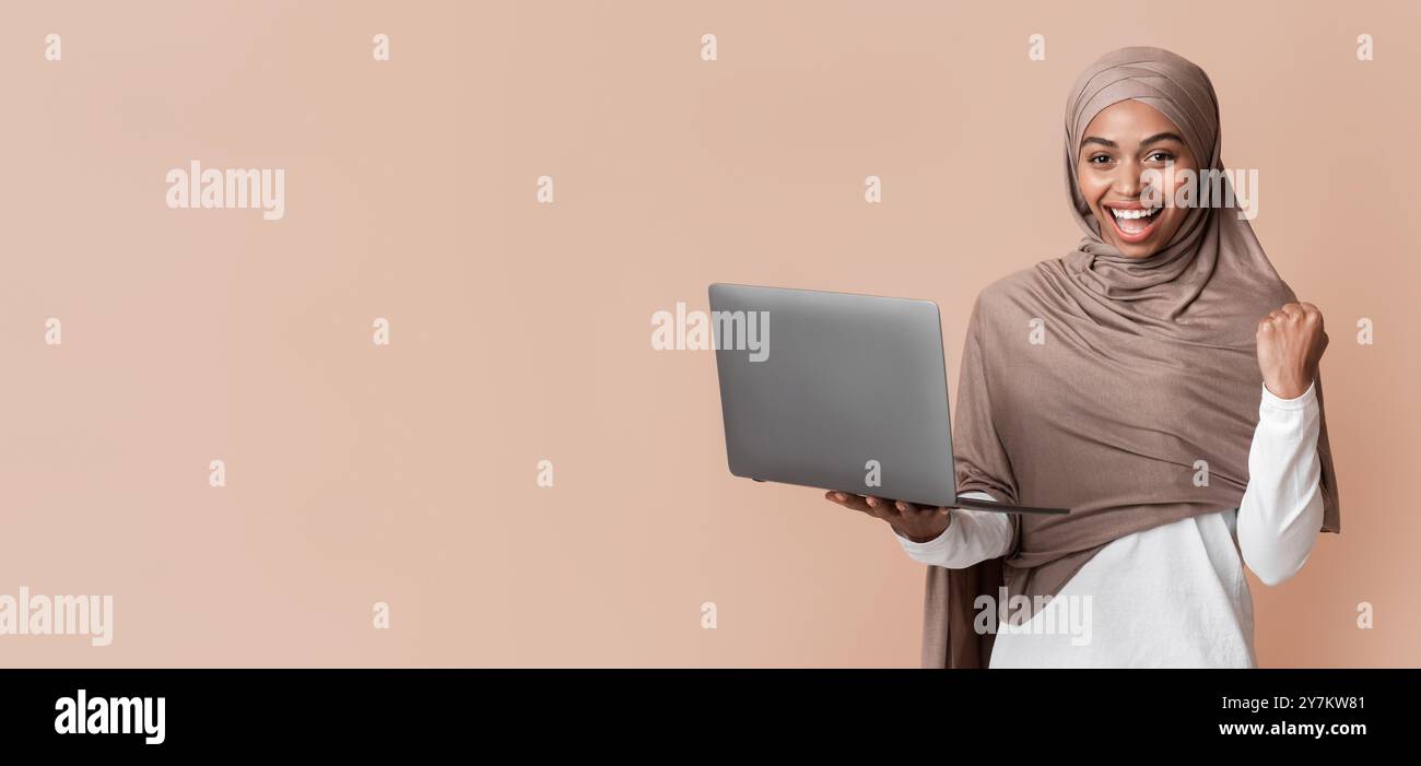 Cheerful Afro Muslim Girl In Headscarf Rejoicing Success With Laptop ...