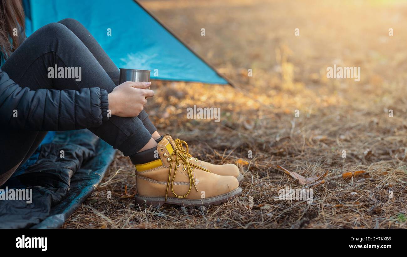 Legs in boots of woman camping in forest Stock Photo - Alamy