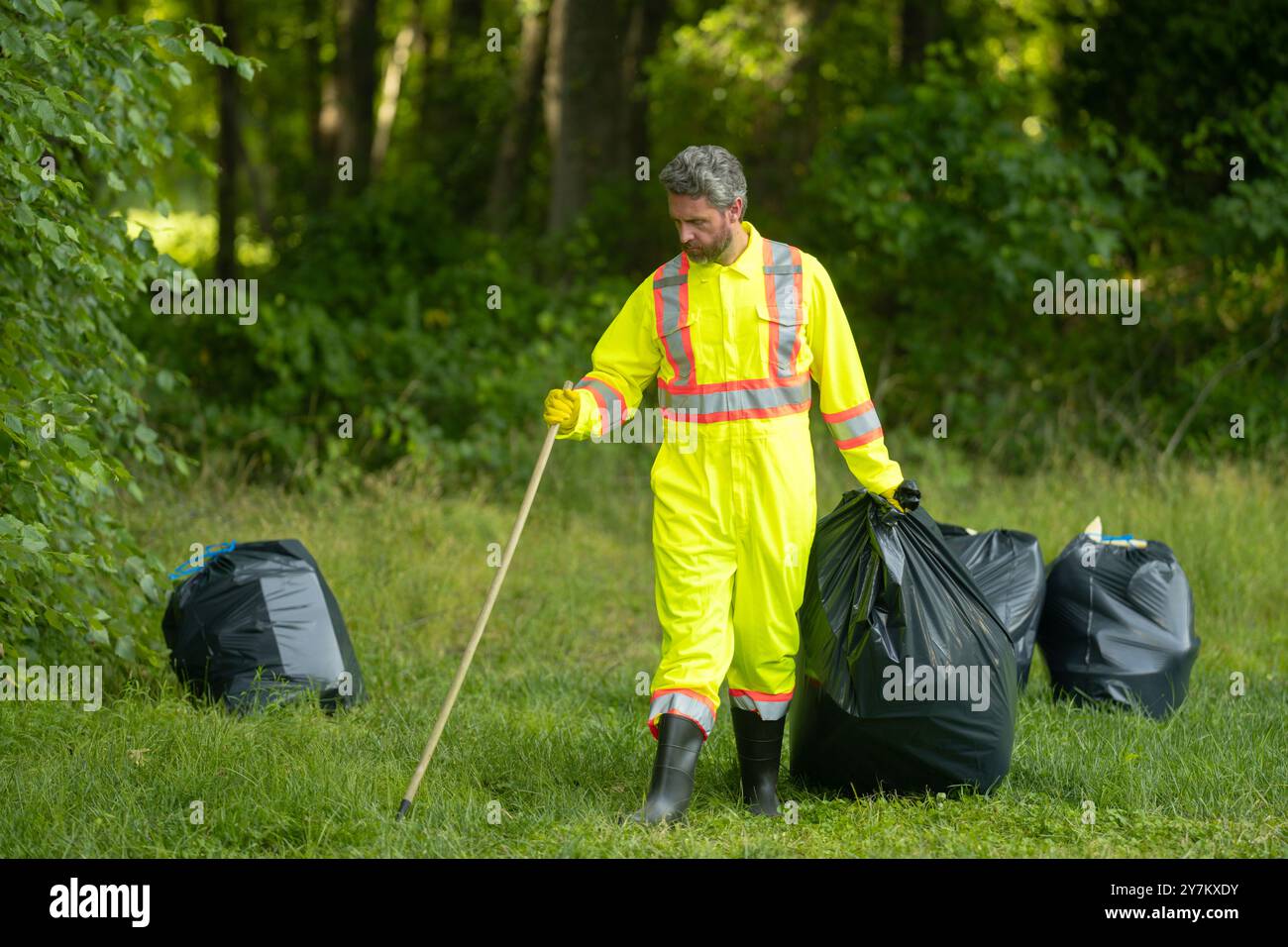 Man in uniform picking up garbage plastic for cleaning. Man collecting ...