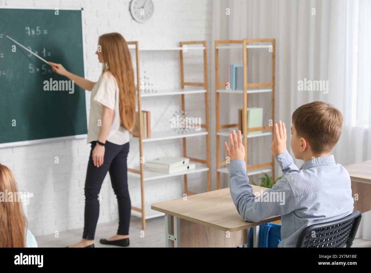 Little boy showing numbers with his hands during lesson in classroom ...