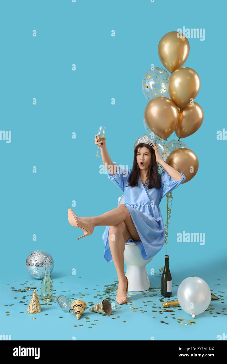 Drunk young woman with champagne sitting on toilet bowl after Birthday ...