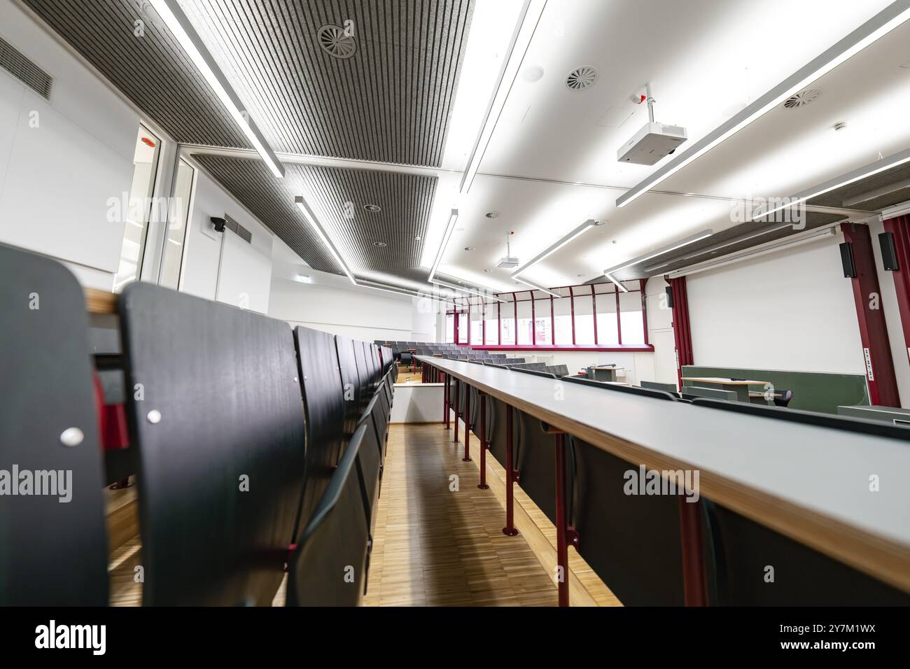 Modern lecture theatre with several rows of seats and neutral design ...