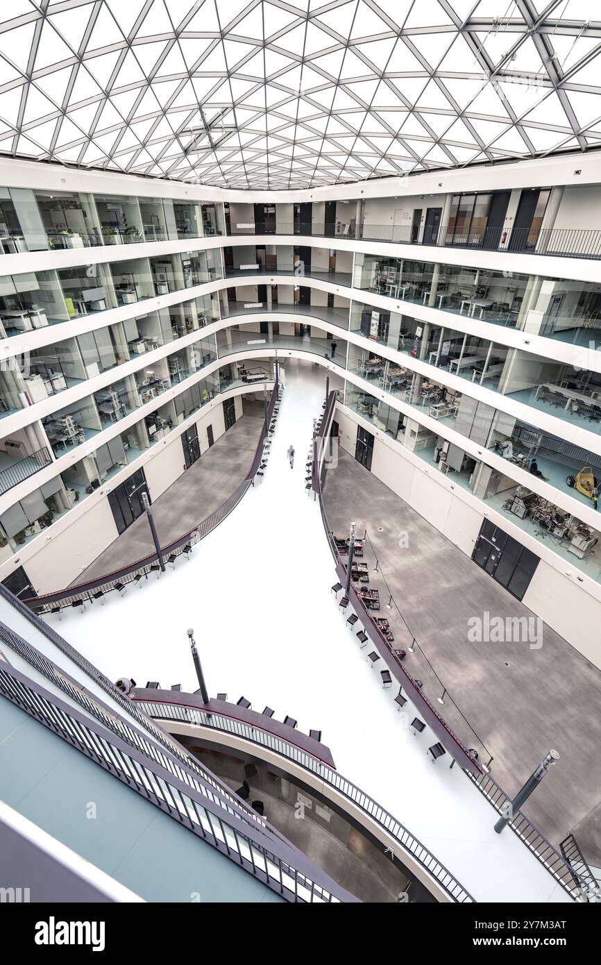 Open interior of a modern office building with glass roof and ...