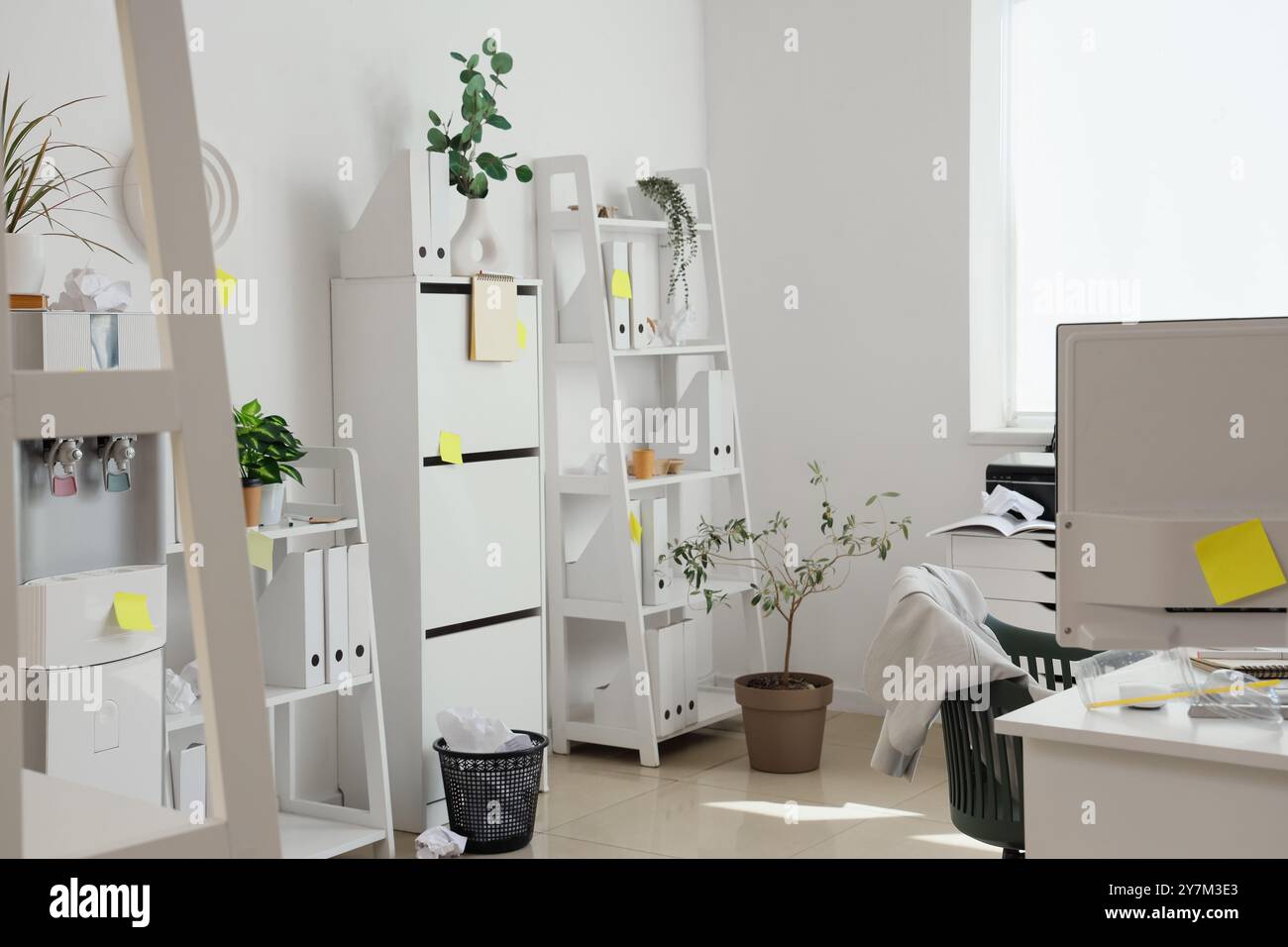 Interior of messy office with workplace, shelf units and sticky notes ...