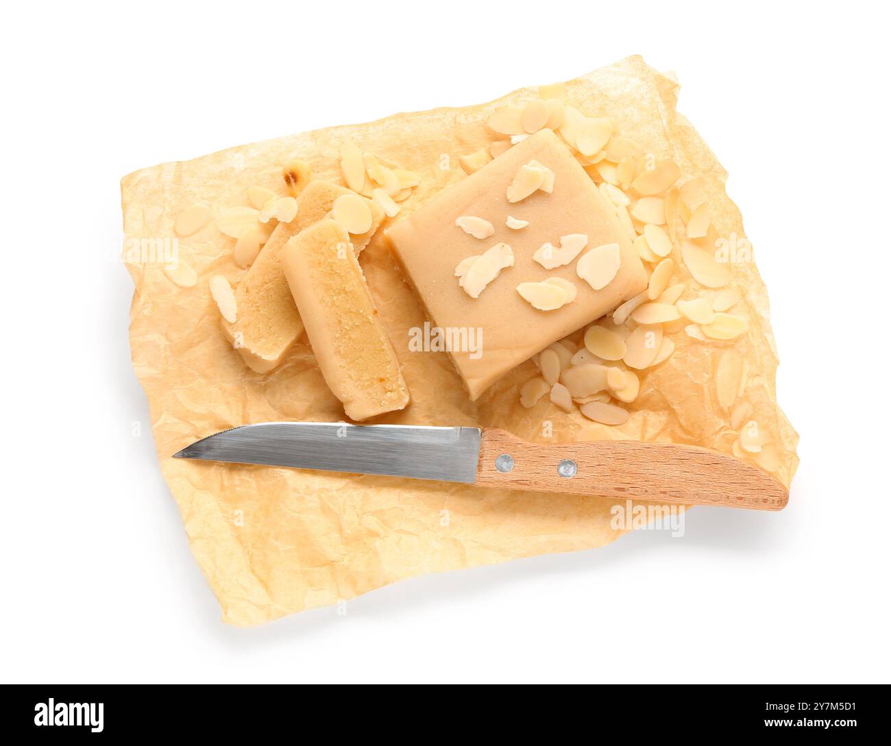 Baking paper with marzipan, almond flakes and knife on white background ...