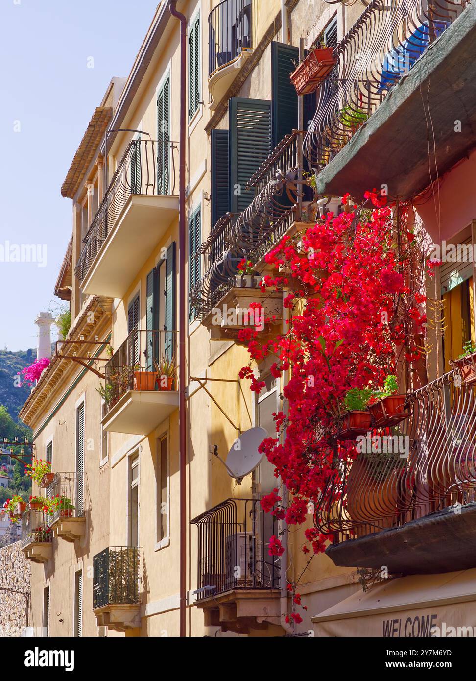 Building facades and balconies in Taormina streets full of ...