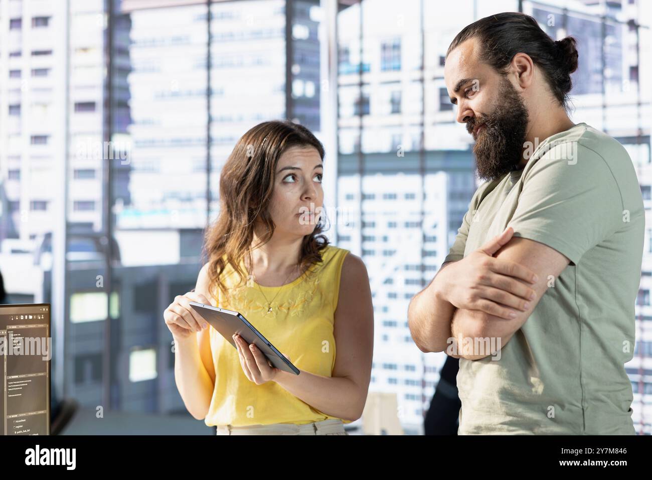 Team of data science workers conducting code review on tablet to fix bugs, identifying technical ...