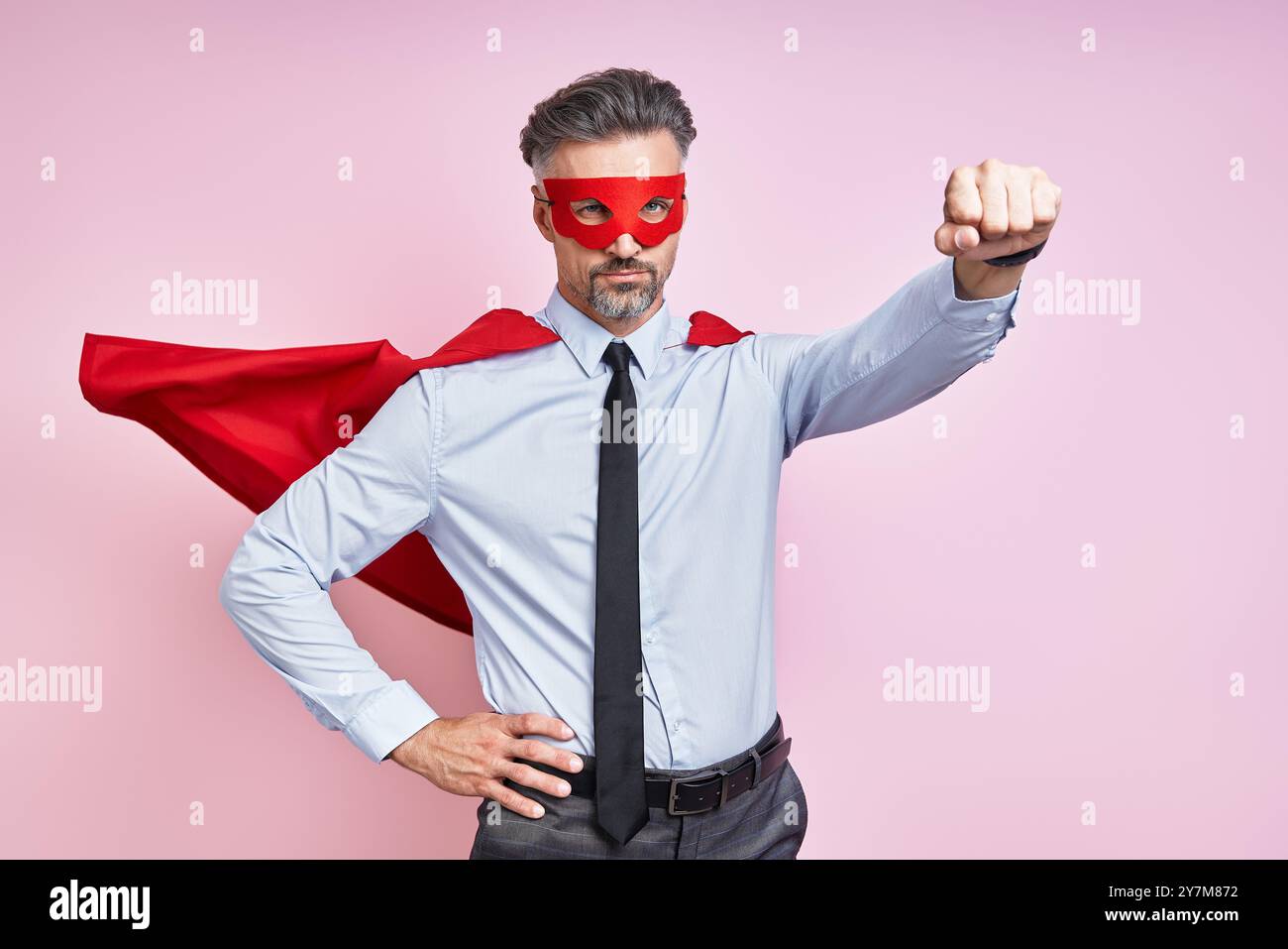 Confident mature man wearing superhero cape and keeping arm ...