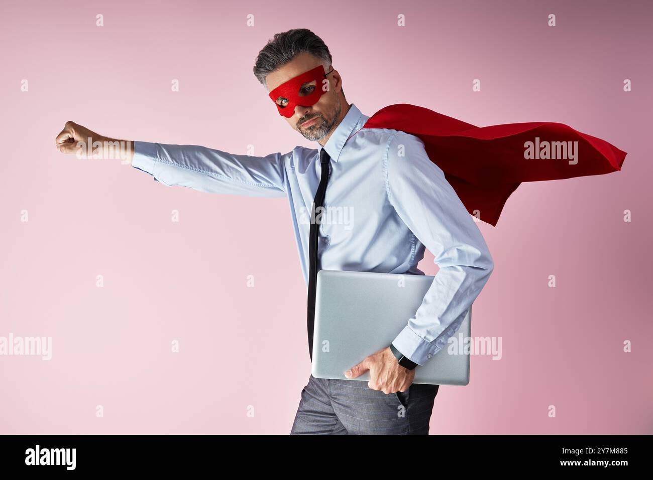 Confident man in shirt and tie wearing superhero cape and carrying ...
