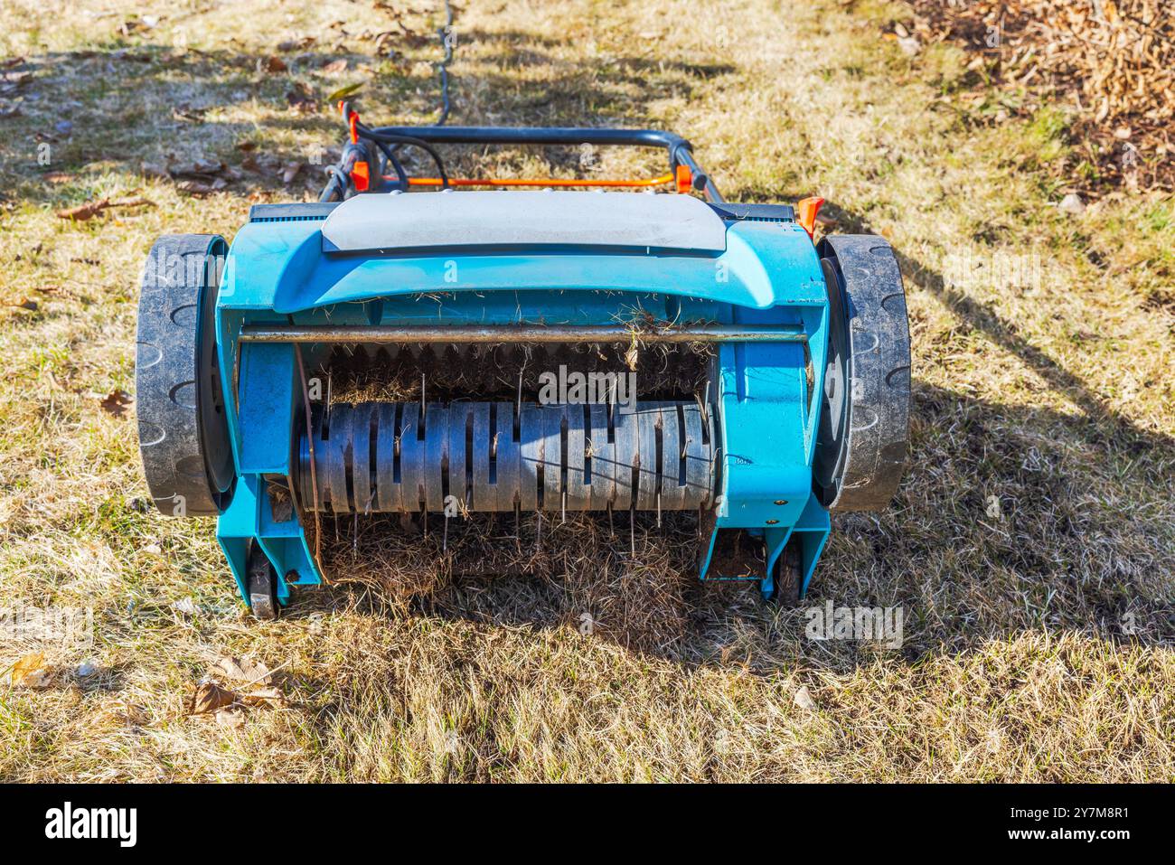 Electric lawn scarifier in spring garden during lawn maintenance with ...