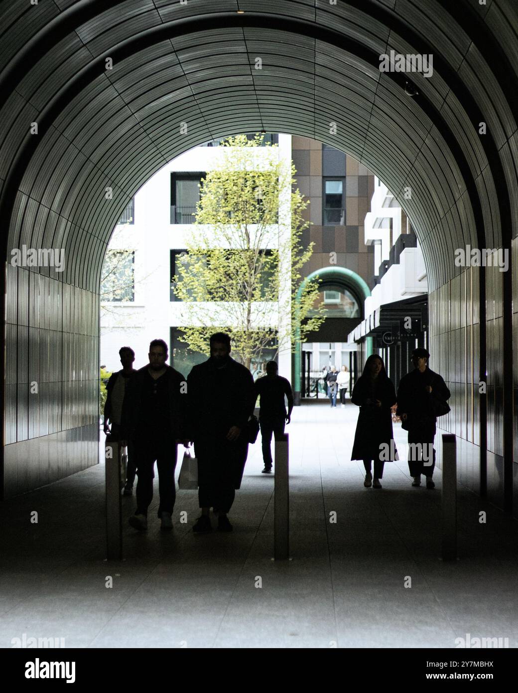People silhouettes walking under an arcade in London close to Oxford ...