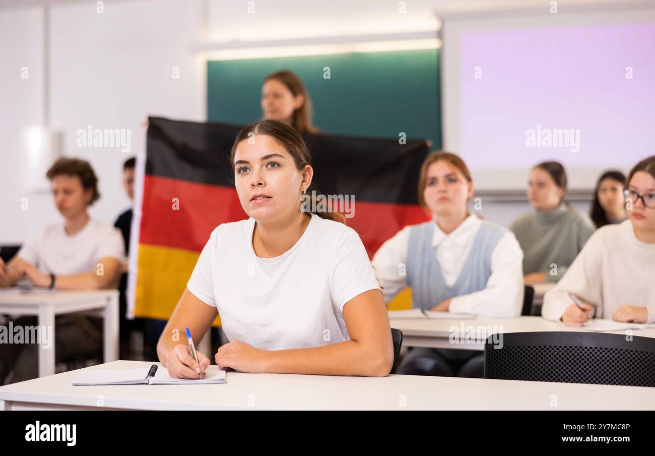 Teacher stands behind students with German flag Stock Photo - Alamy