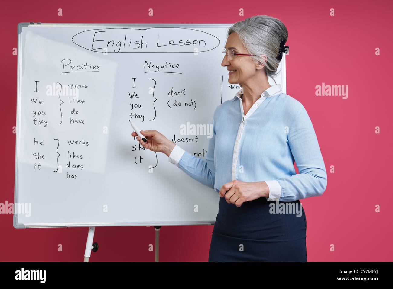 Senior woman teaching English language while standing near the ...