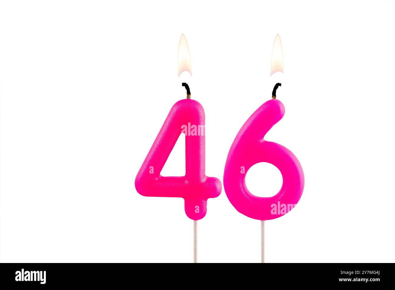 Pink number 46 birthday candle lit on white background Stock Photo - Alamy