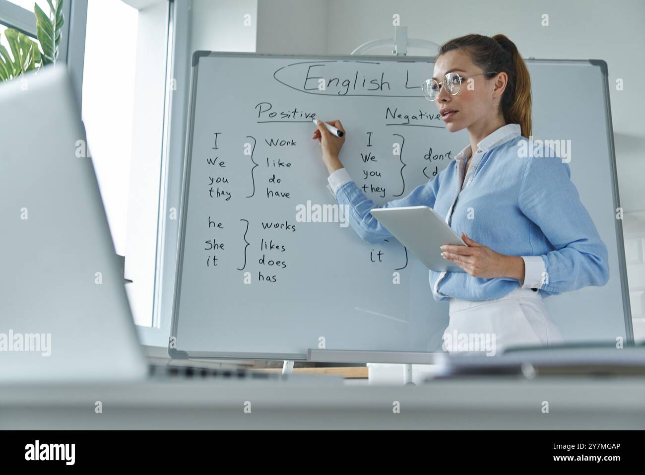 Confident female teacher pointing whiteboard while having web ...