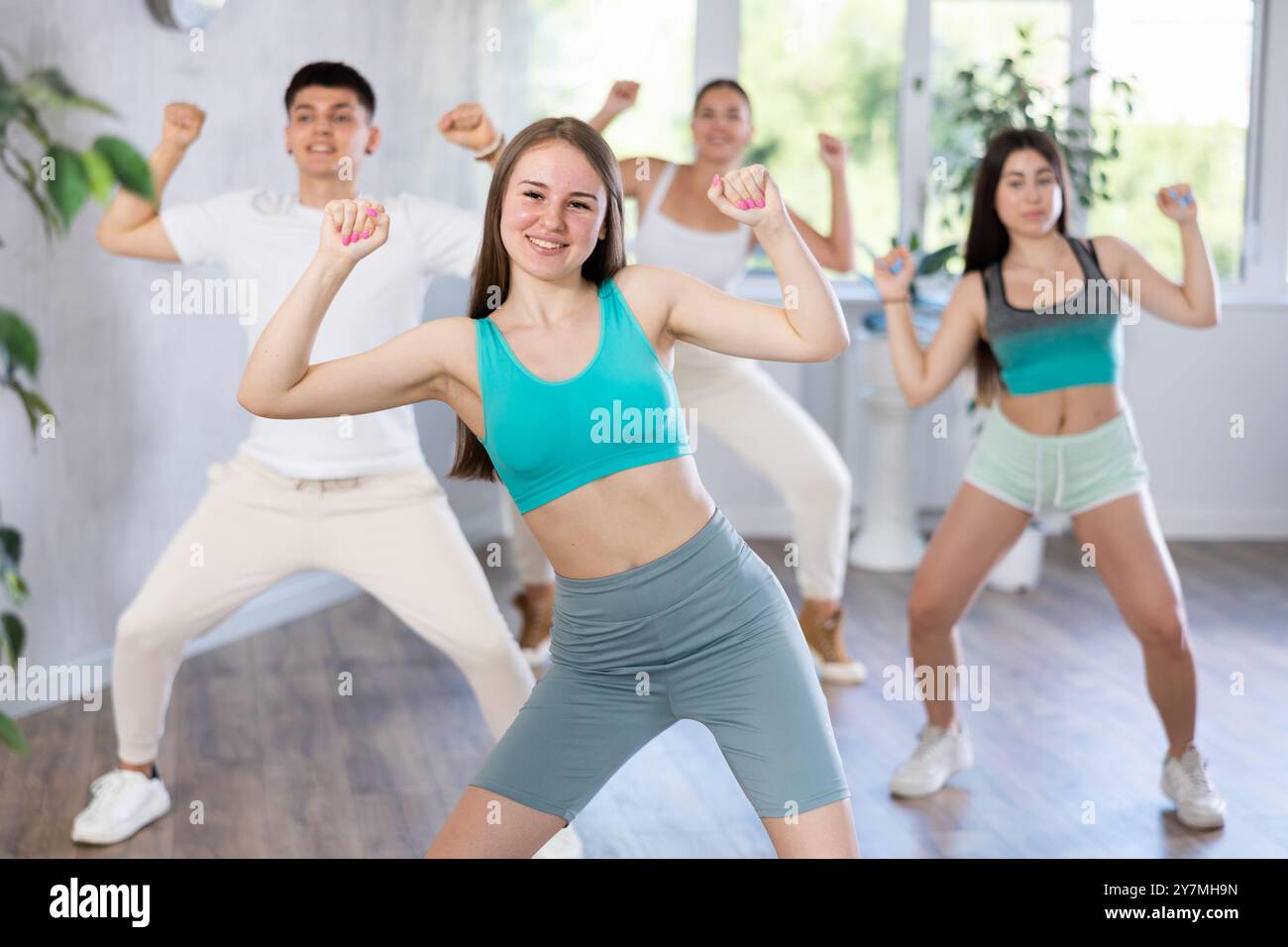 Teenage girl practicing hip-hop movements during group dance class ...