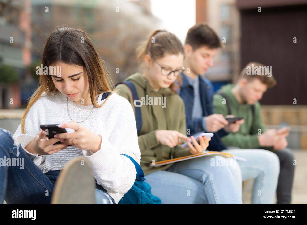 Teenage friends holding phones Stock Photo - Alamy