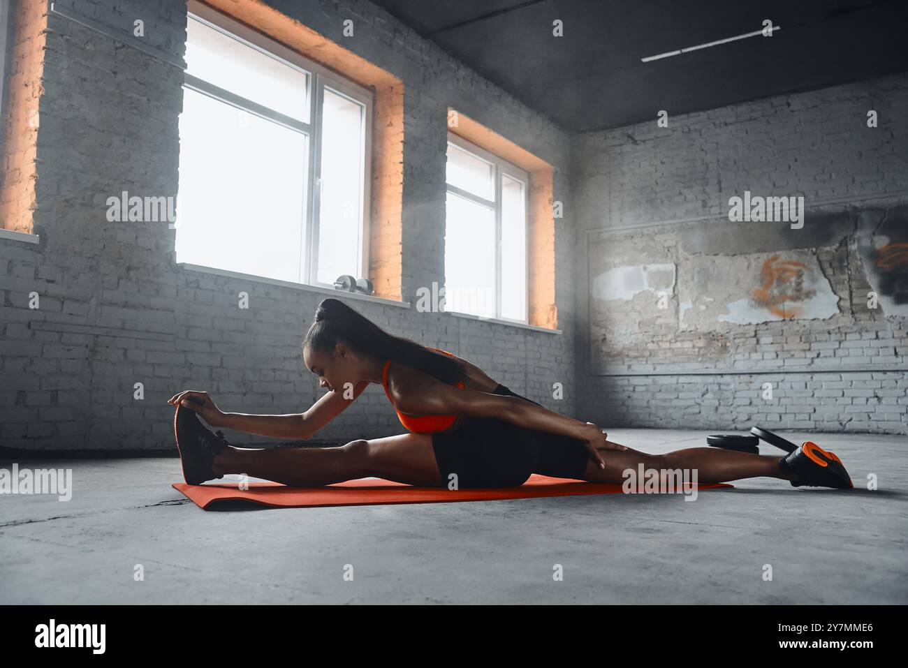 Attractive young African woman stretching on splits in gym Stock Photo ...