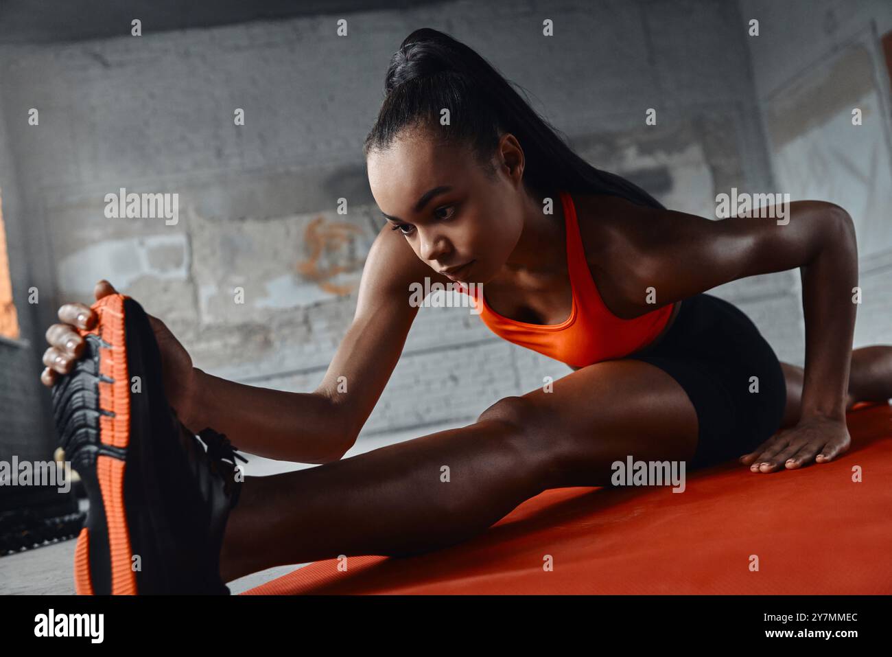 Confident young African woman stretching on splits in gym Stock Photo ...