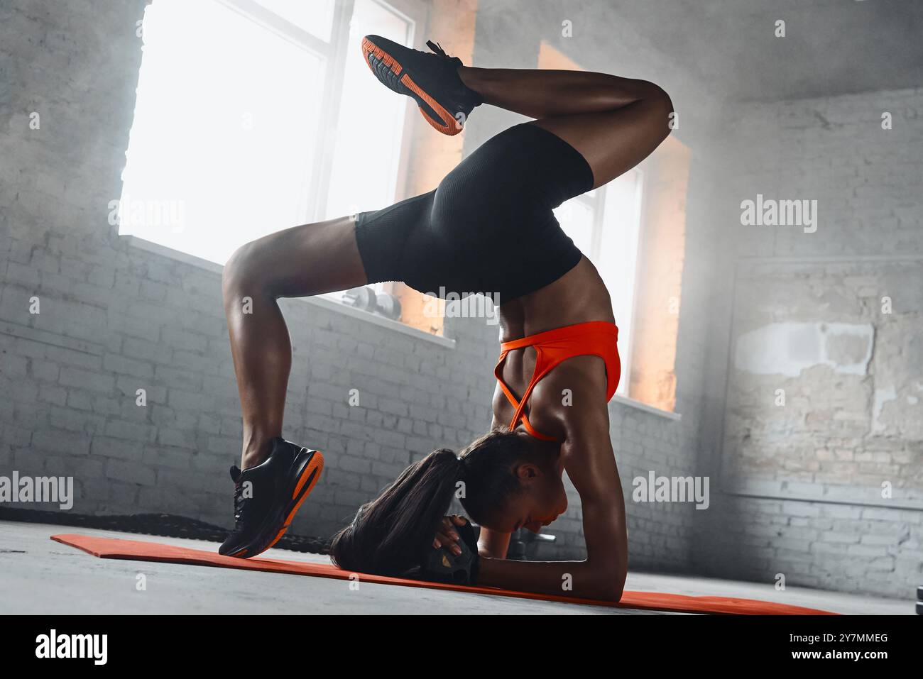 Beautiful young African woman doing handstand splits in gym Stock Photo ...