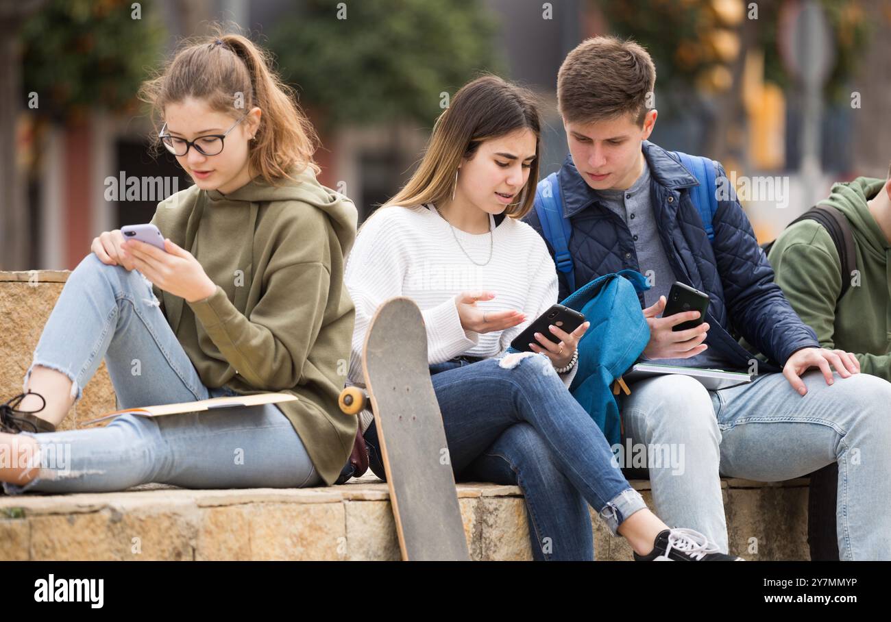Group of teens using smartphones outdoors Stock Photo - Alamy