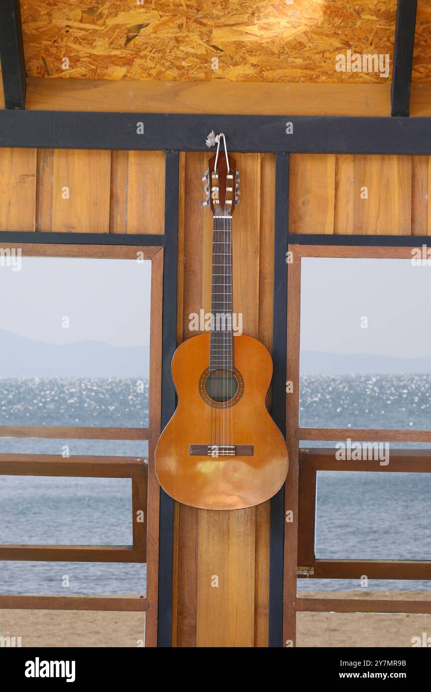 Classical Guitar hanging on the wall of the house with day sea view in ...