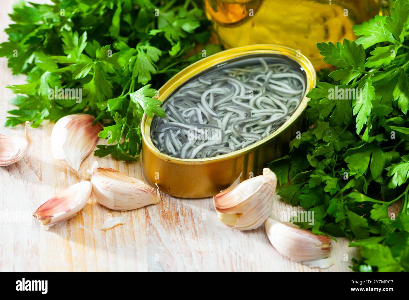 Pickled eels on background with garlic and greens at table Stock Photo ...