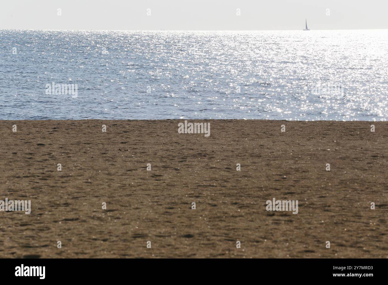 Beach and the sea with the sunlight reflecting on the sparkling sea ...