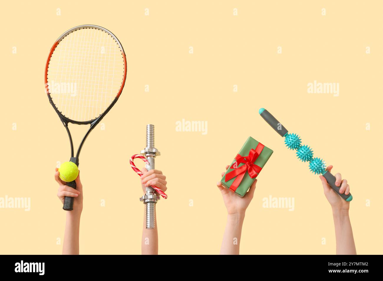 Female hands holding tennis racket, tennis ball, dumbbell bar, candy ...
