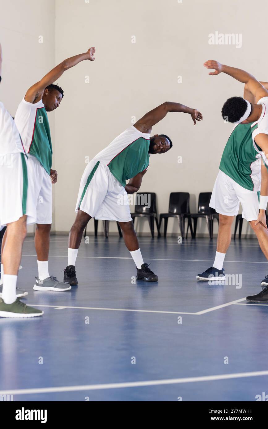 Diverse Basketball players stretching and warming up before game on ...