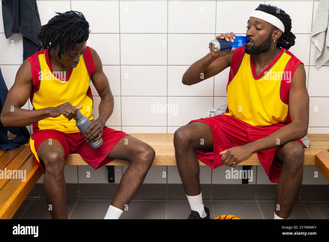 Drinking water, African American basketball players in locker room ...
